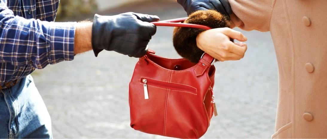 Pessoa tentando roubar bolsa de mulher