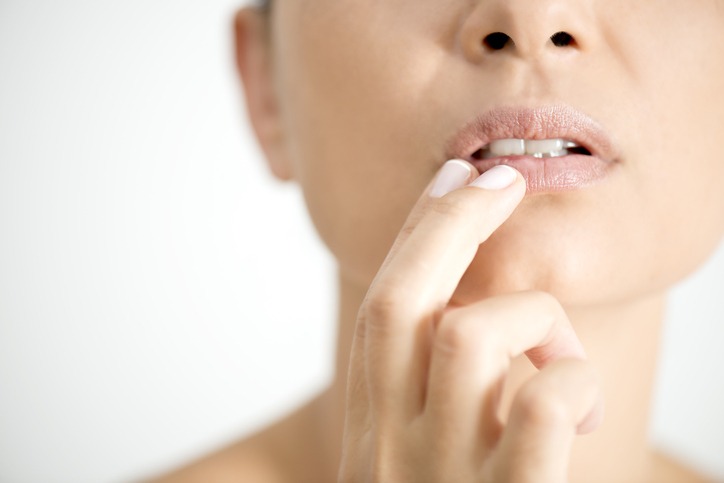 Close up de mulher examinando os lábios para identificar sintomas de herpes